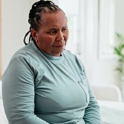 Senior African woman, sad and bedroom in retirement with thinking of grief, mental health and ...