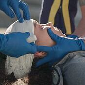 First aid, hands of paramedic and bandage on woman in accident, head ...