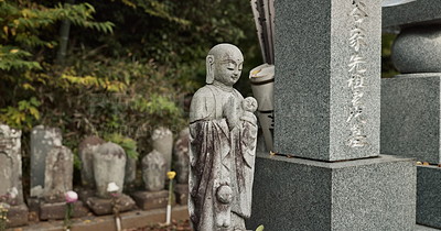 Stone statue in traditional Japanese graveyard with peace, calm and ...