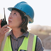 Woman, construction and inspection with radio for communication ...