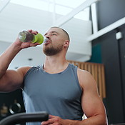 Exercise, health and hydration with man drinking water in gym for break ...