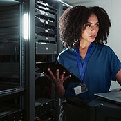 Tablet, engineer and woman on laptop in server room for cyber security, coding or update ...