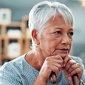 Senior woman, thinking and living room with walking stick, grief and retirement home with ...