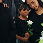 Funeral, family and woman with child at coffin with flower at memorial ...