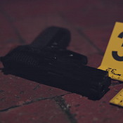 Gun, evidence and sign at crime scene in street with homicide, danger ...