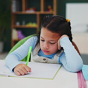 Girl, bored and frustrated with school, writing and assignment for ...