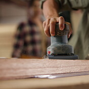 Man, carpenter and sanding woodwork in workshop with machine for ...