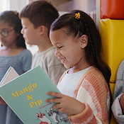 Happy, children and reading in classroom together for educational ...
