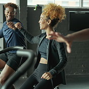 Fitness, people and fist bump for exercise bike challenge at gym with ...