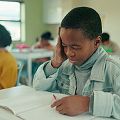 Boy, headache and child in school or classroom, burnout and tired for ...