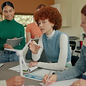 Students, teacher and windmill in classroom for learning, environmental ...