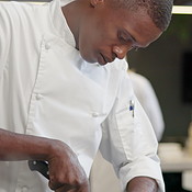 Black man, chef and cutting green onion fast in kitchen for food ...