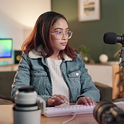 Podcast, woman and influencer with typing, computer and speaking with ...