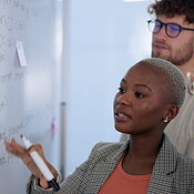 Business people, coding and communication with whiteboard for planning ...