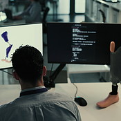 Data, development and person at computer screen with prosthetic leg ...
