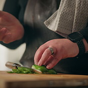 Hands, wrist pain and man in kitchen, cutting and chef with ...