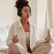 Woman, relax and meditation with headphones on bed for awareness ...