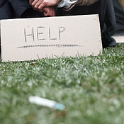 Poverty, sign and help for charity with drug needle, heroin and addict ...
