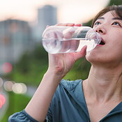 Woman, drinking water and athlete in city for hydration, Japan and ...