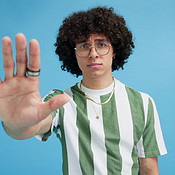 Stop, hand and face of man in studio for rejection, refuse and protest ...