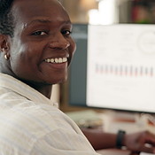 Face, business and happy black man on computer with stats, finance ...