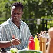 Food, laughing and party with friends in garden for funny joke, summer ...