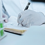 Hand, writing notes and scientist in laboratory for experiment, test or ...