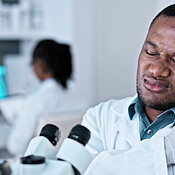 Microscope, science and shoulder pain with black man in lab for ...