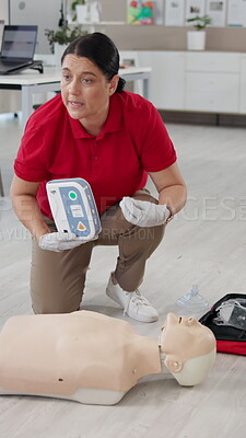 CPR, defibrillator and dummy with woman in office for rescue or ...