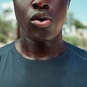 Athlete, sweating and man with tired breathing at stadium for running ...