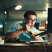 Eating, night and man with laptop, hungry and multitasking for video ...