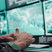 Hands, person and typing on computer screen in control room, military ...