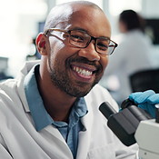 Face, science and man with microscope in lab for research innovation ...