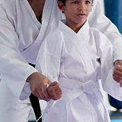 Sensei, training and teaching karate to kid in class for combat sports ...