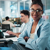 Arms crossed, face and smile of programmer woman at desk in office as ...