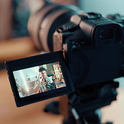 Man, video camera and screen with online tutorial for content creation ...