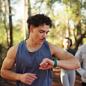Man, smart watch and trail running in forest with group, challenge and ...