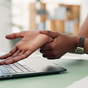 Laptop, typing and hands with wrist pain at office desk, muscle sprain ...